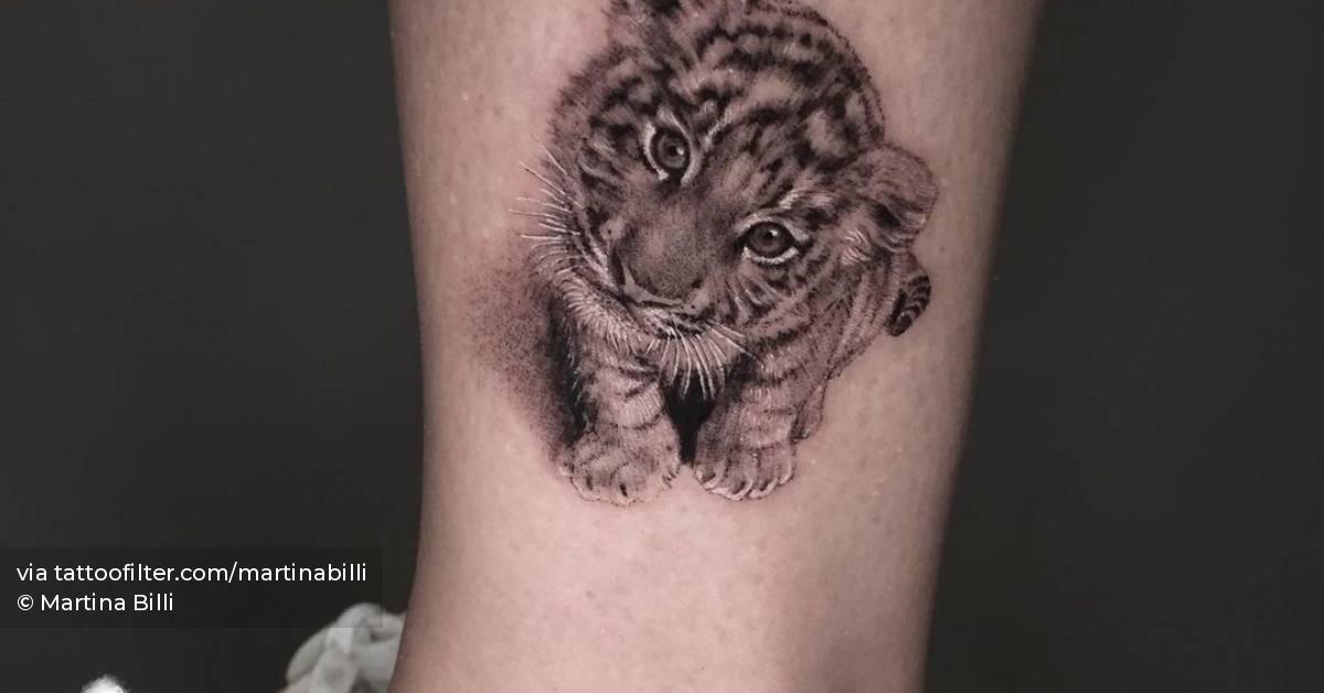 Micro-realistic tiger cub tattoo on the ankle.