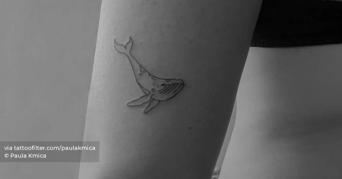 Fine line whale tattoo placed on the tricep.