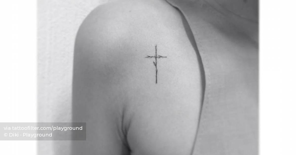 Fine line flower cross tattoo located on the shoulder.