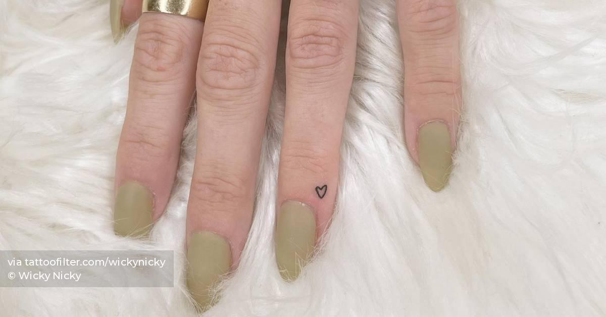 Micro heart tattoo located on the finger.