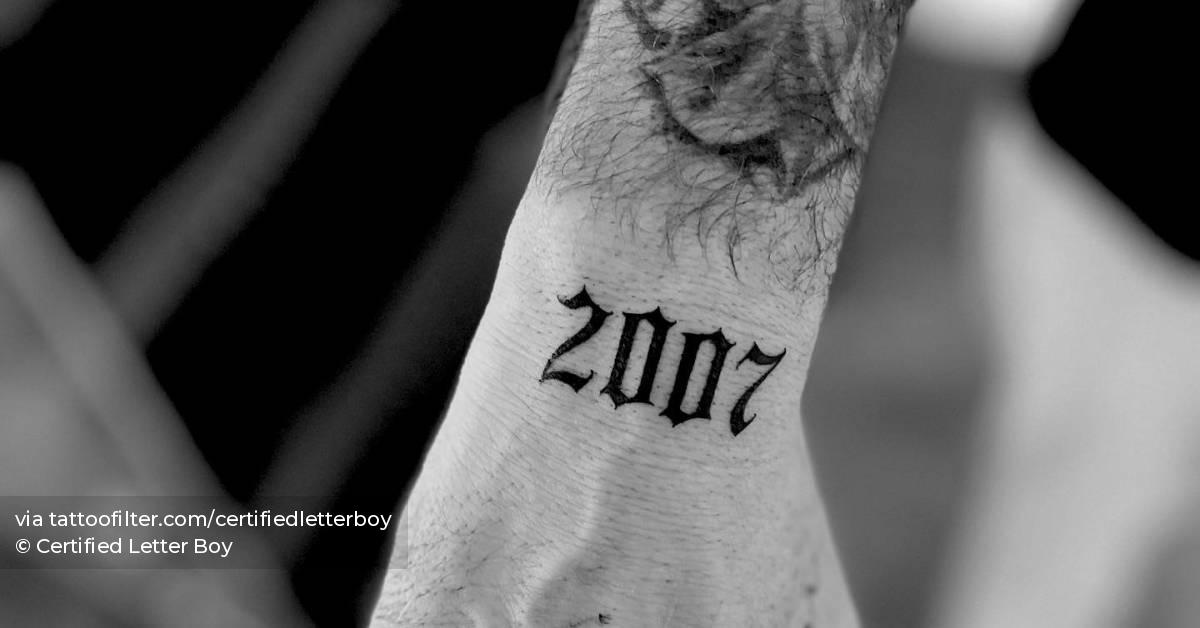 "2007" lettering tattoo located on Fat Tony's wrist.