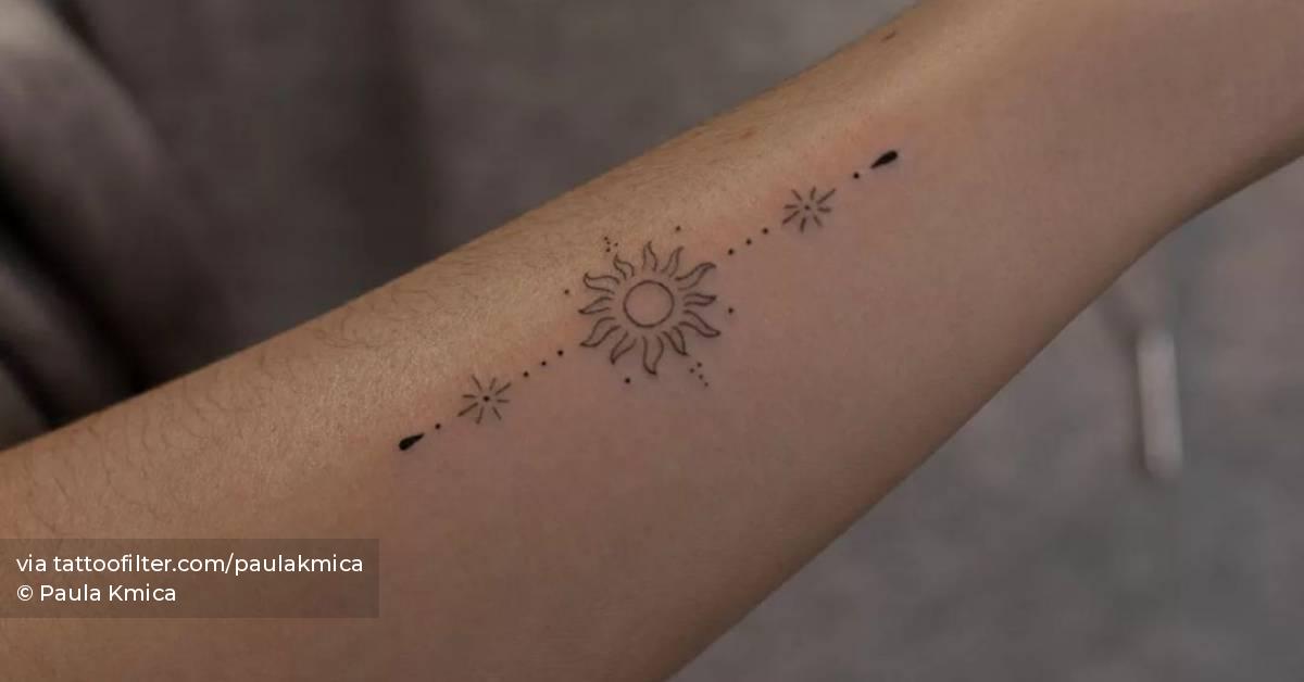 Fine line ornamental sun tattoo located on the wrist.