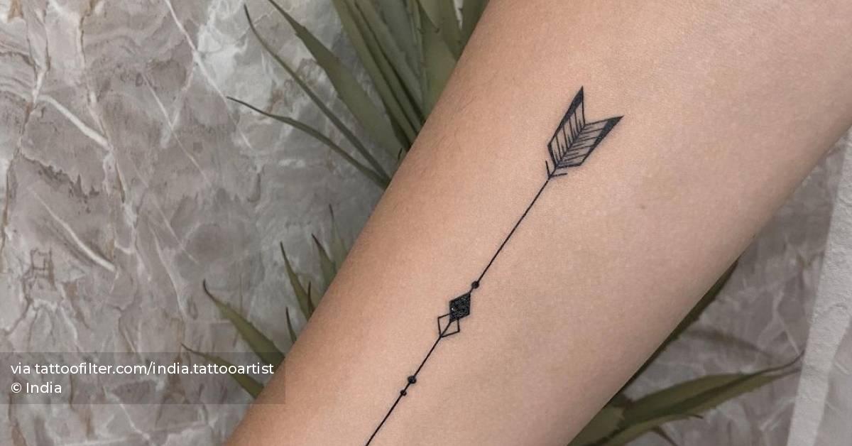 Fine line arrow tattoo on the inner forearm.