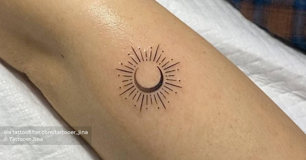 Fine line sun and moon tattoo on the forearm.