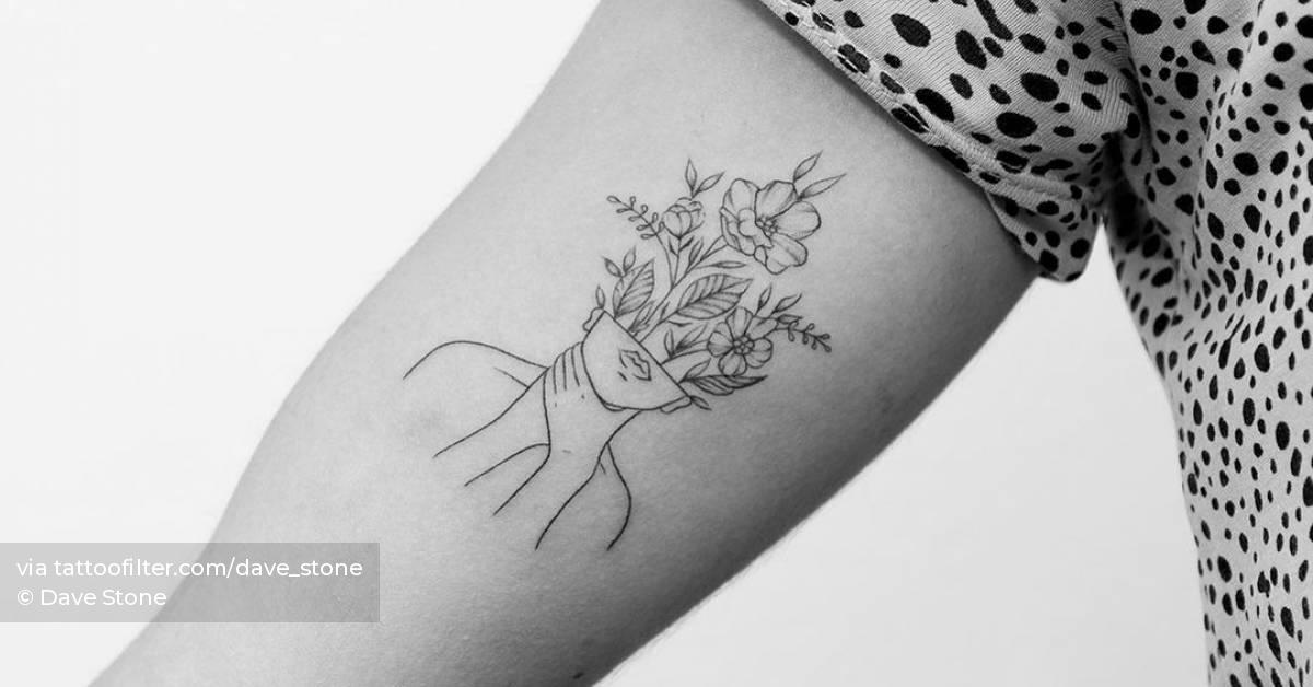 Fine line flower head woman tattoo on the inner arm.