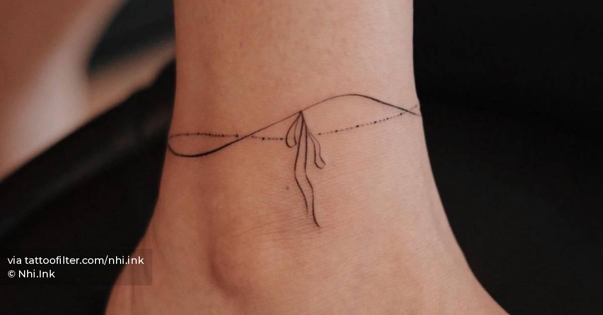 Fine line ankle band tattoo, minimalistic style.