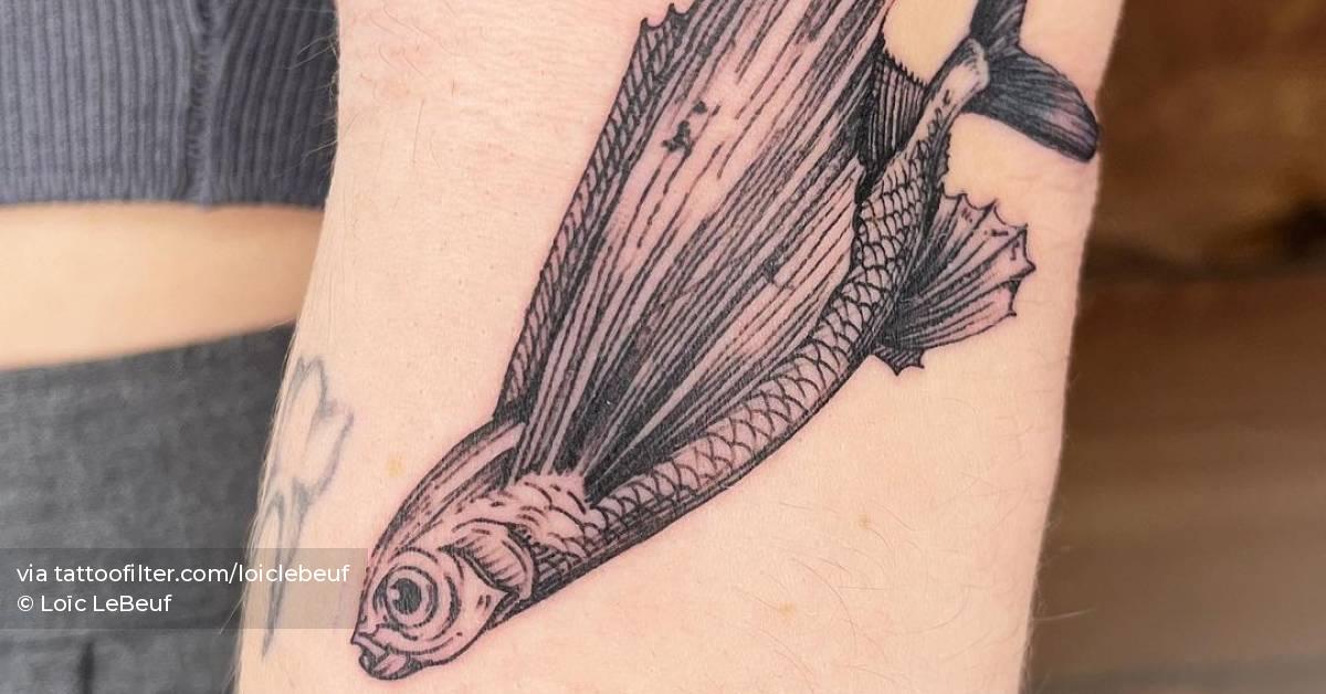 Flying fish tattoo located on the elbow.