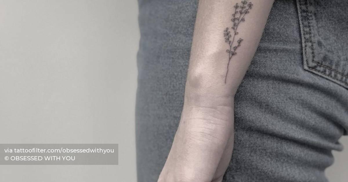 Fine line lavender tattoo located on the wrist.
