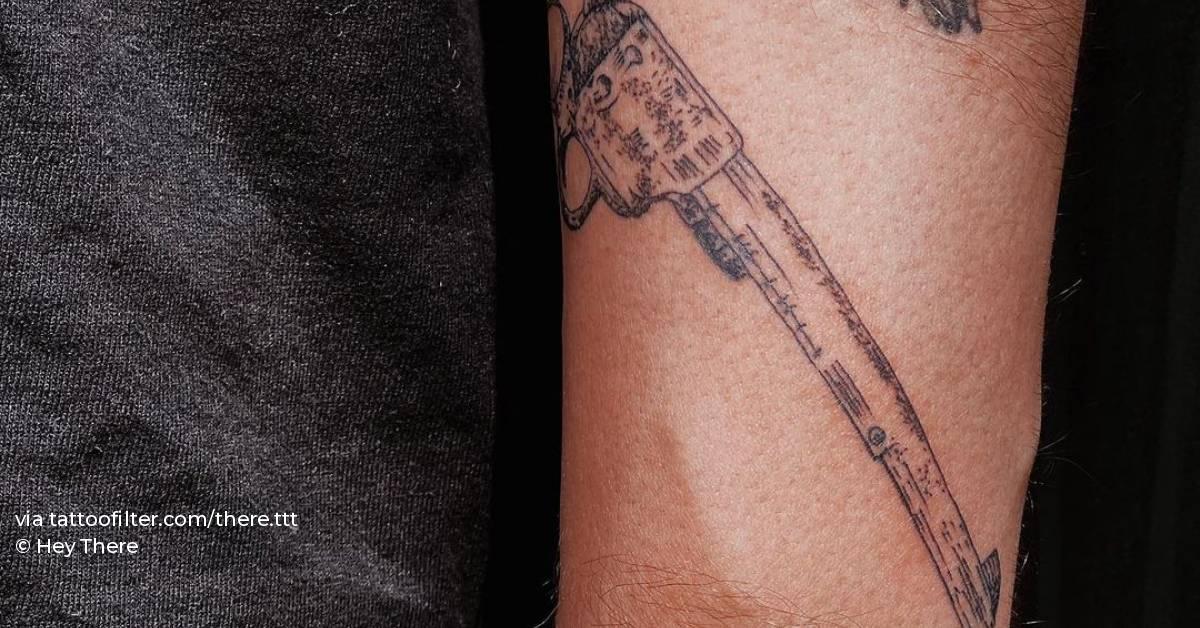 Revolver tattoo located on the forearm.