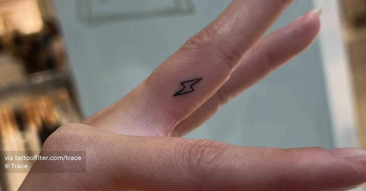 Tiny lightning bolt tattoo located on the finger.