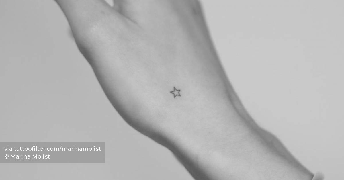 Super tiny minimalistic star tattoo located on the