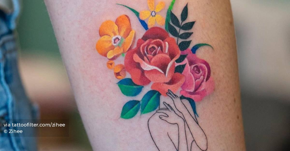 Flower head woman tattoo on the inner forearm.