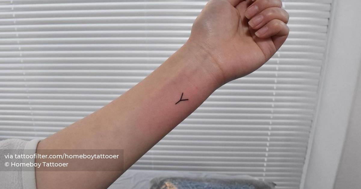 Minimalist letter "Y" tattoo on the wrist.