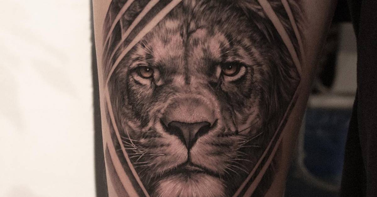 Realistic lion portrait tattoo located on the thigh.