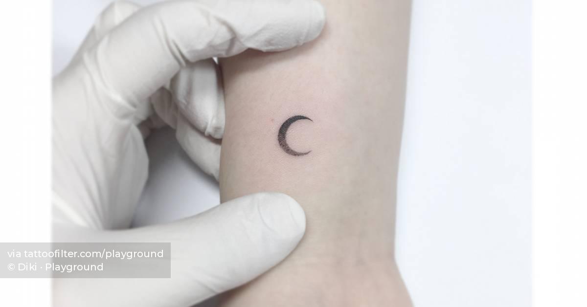 Minimalistic style spectrum moon tattooed on the wrist.