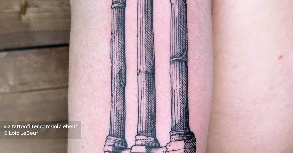 Engraving style columns tattoo located on the tricep.