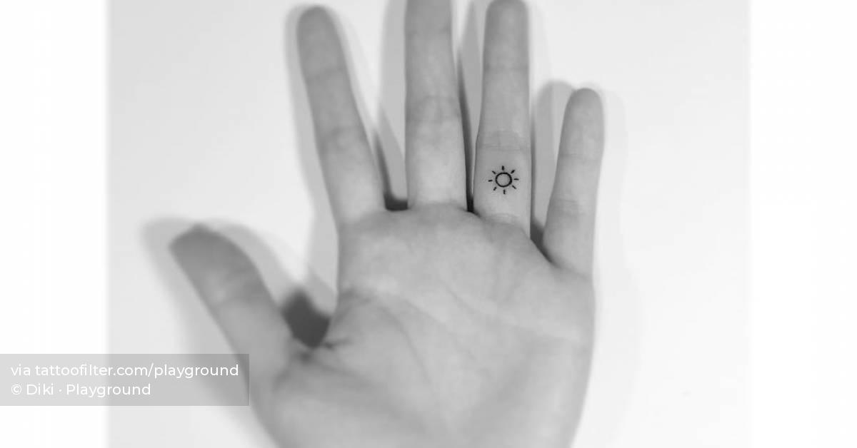 Minimalistic style sun tattoo located on the finger.