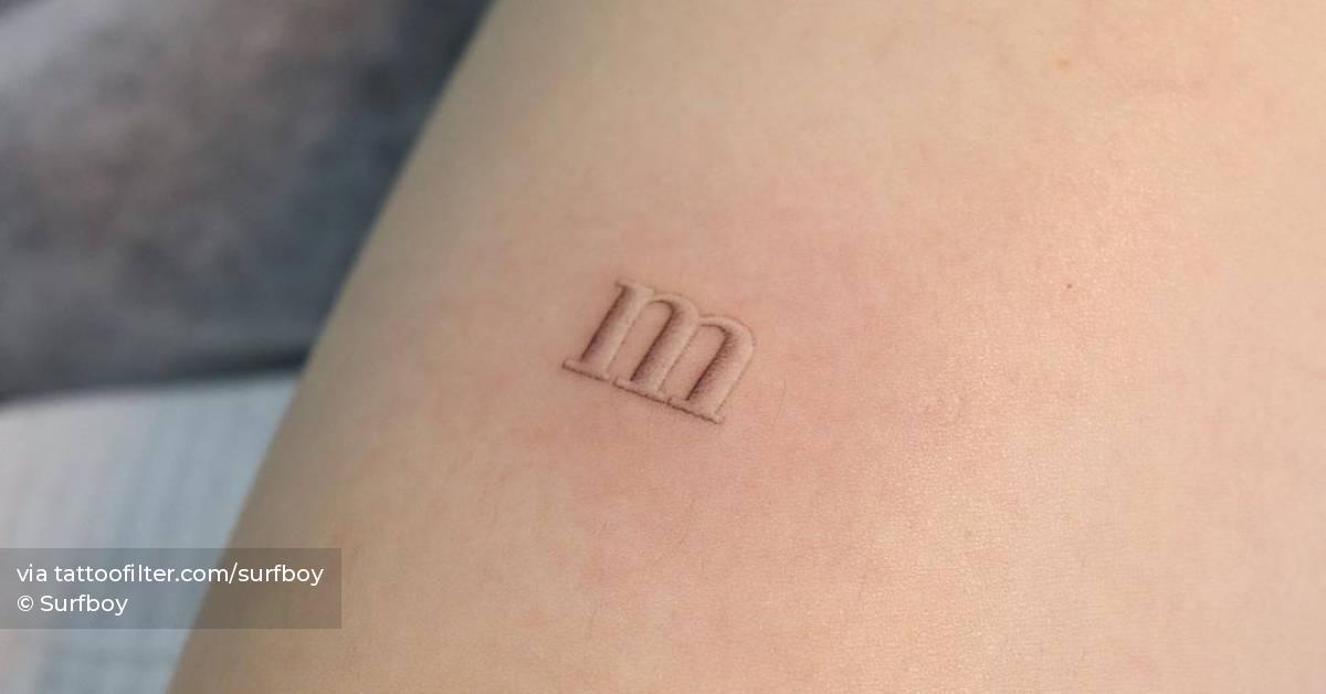 Han poked letter "M" tattoo located on the inner arm.
