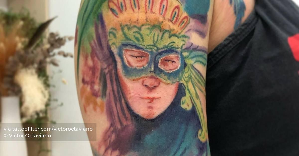 Carnaval themed tattoo located on the upper arm.