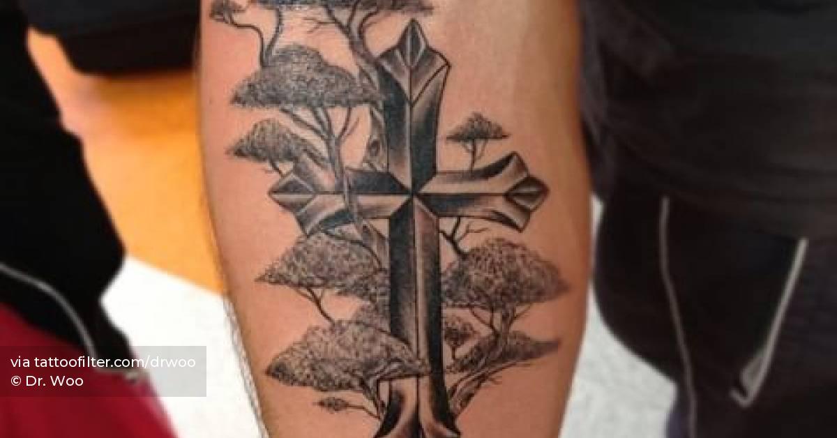 Tree and cross tattoo located on the inner forearm.