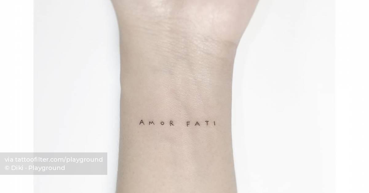 "Amor fati" lettering tattoo located on the wrist.
