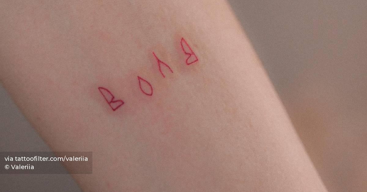 Red lettering tattoo located on the inner forearm.