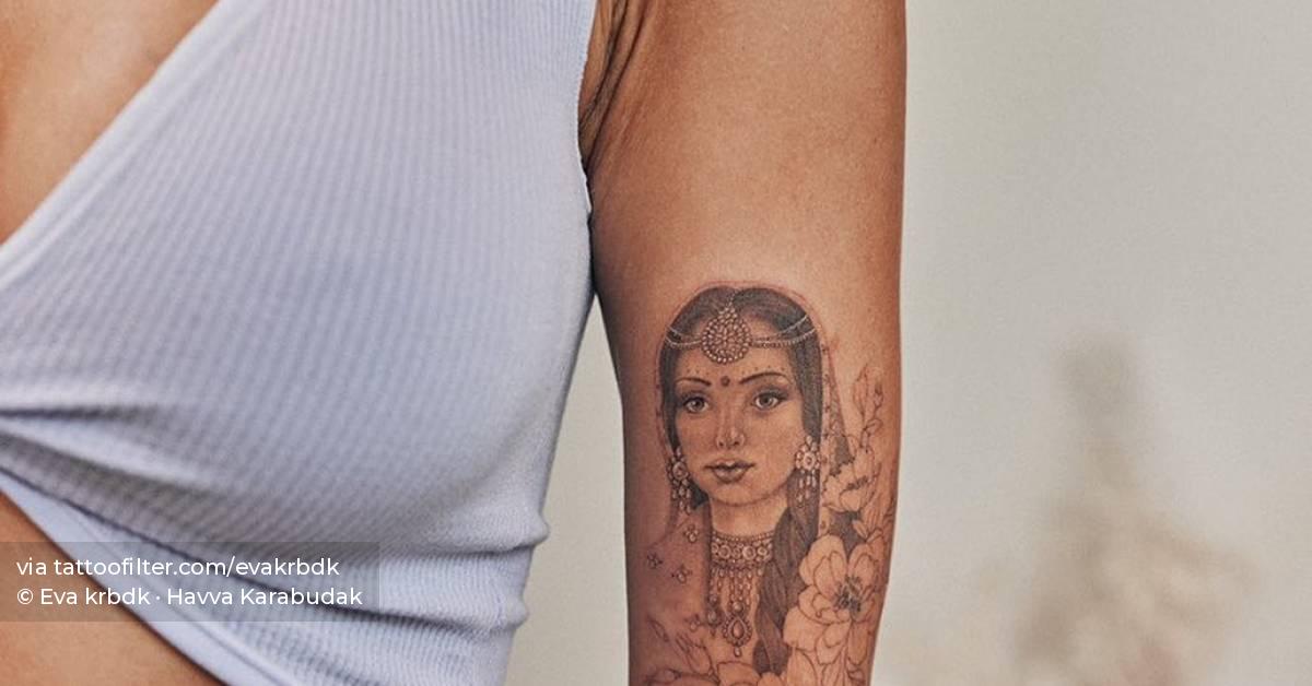 Woman portrait tattoo located on the upper arm.