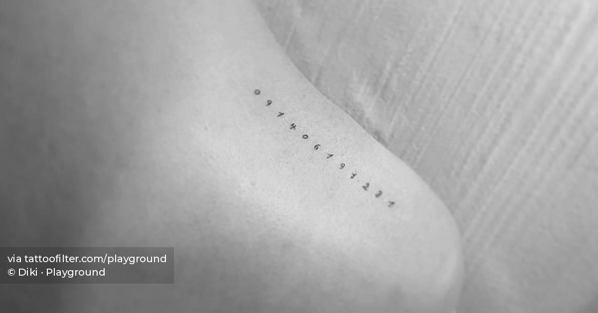 Numbers tattoo located on the top of shoulder.