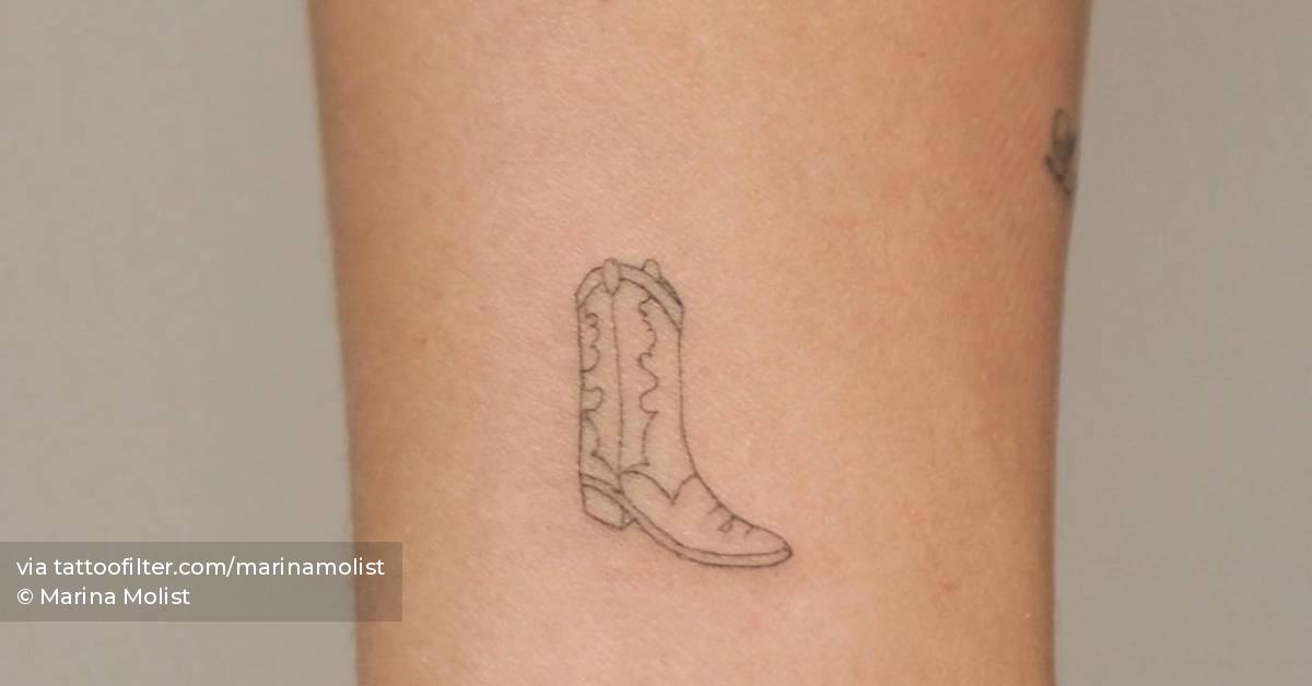 Fine line cowboy boot tattooed on the forearm.