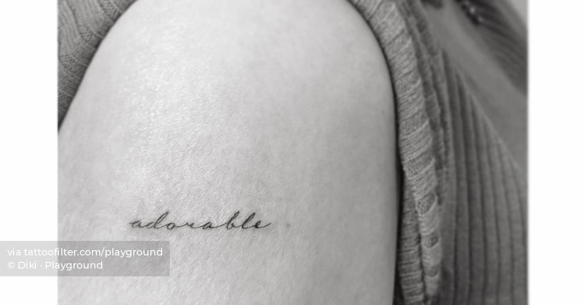 Tattoo of the word "adorable" located on the upper arm.