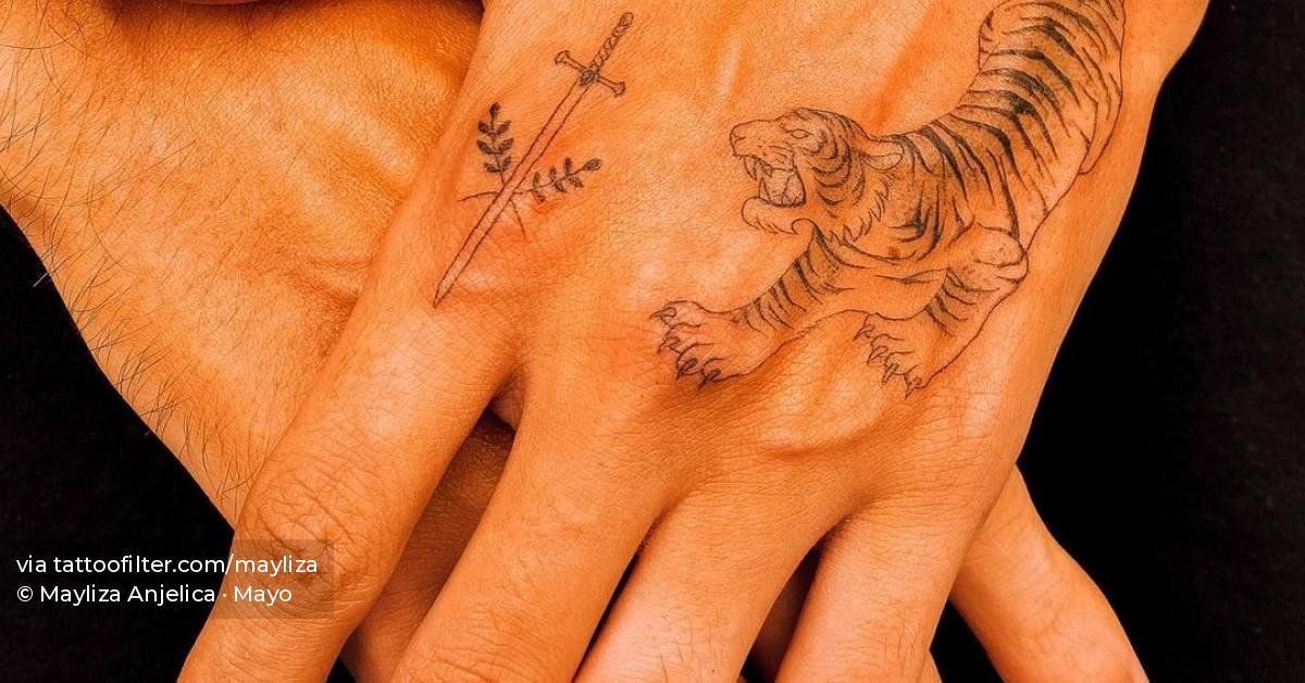 Sword and tiger tattoo located on the hand.