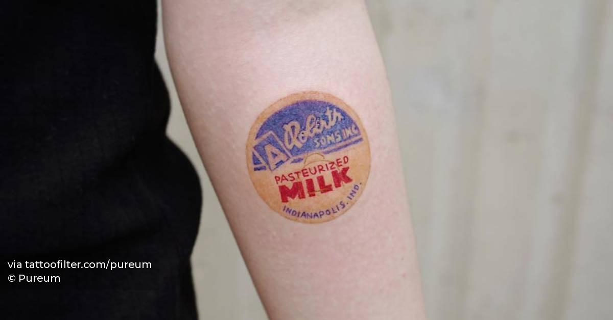 Milk label tattoo located on the inner forearm.