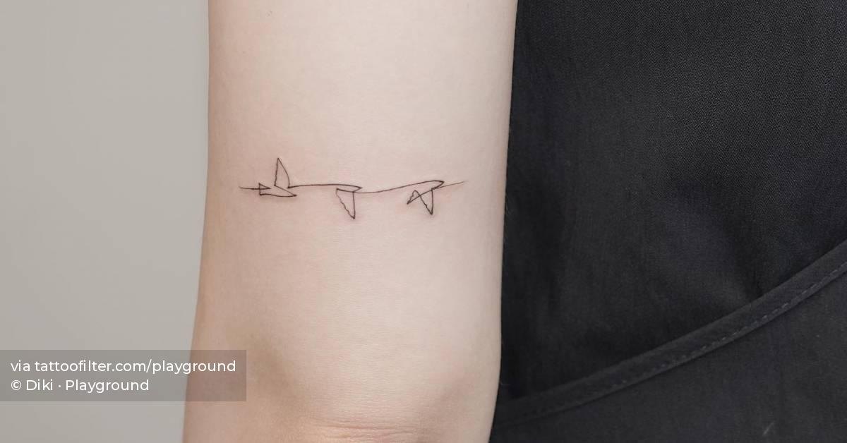 One line flying birds tattoo located on the tricep.