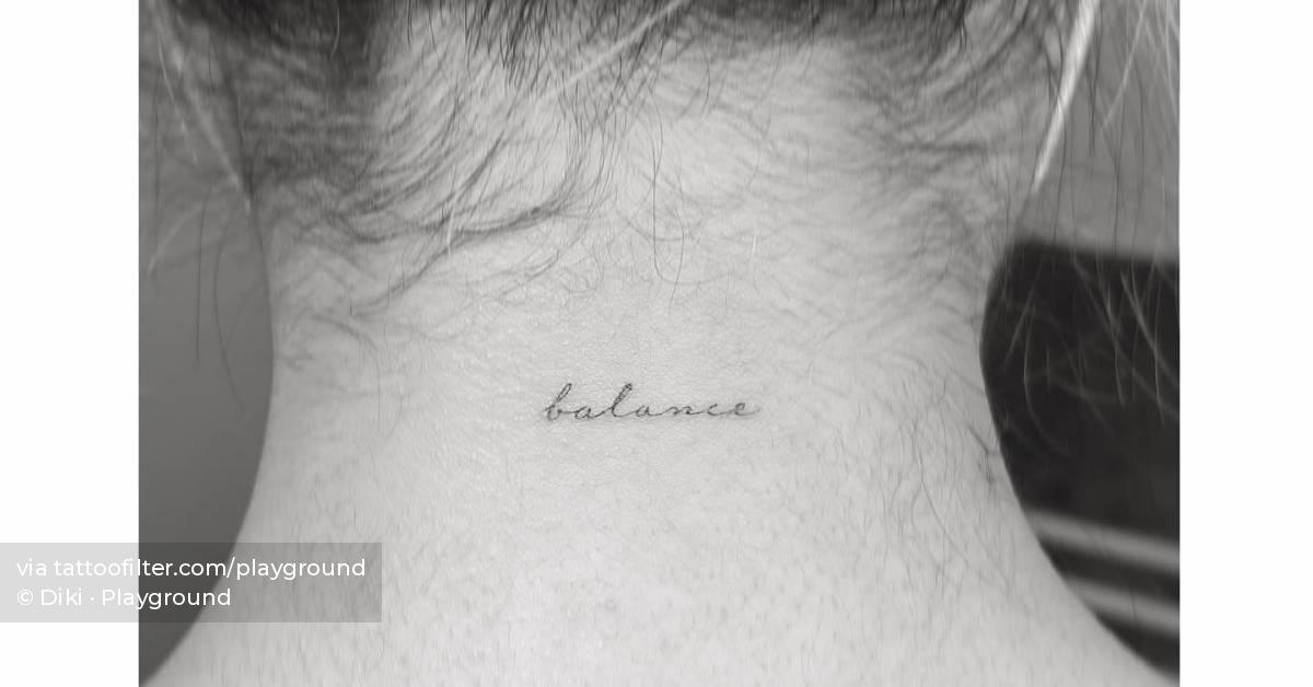 Tattoo of the word "balance" handwritten on the back of