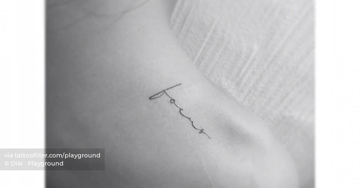 Tattoo of the word "focus" handwritten on the top of