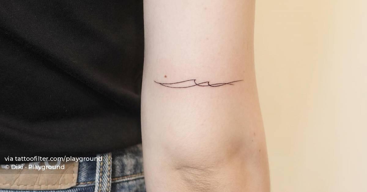 Fine line waves tattoo located on the tricep.