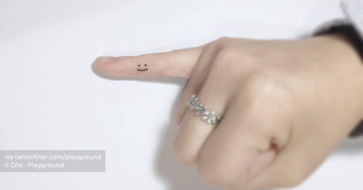 Micro smiley face tattoo done on the finger.