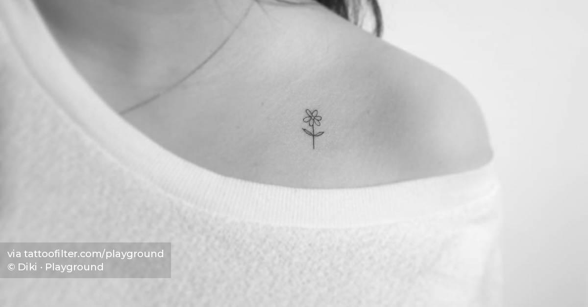 Minimalistic tiny flower tattoo located on the