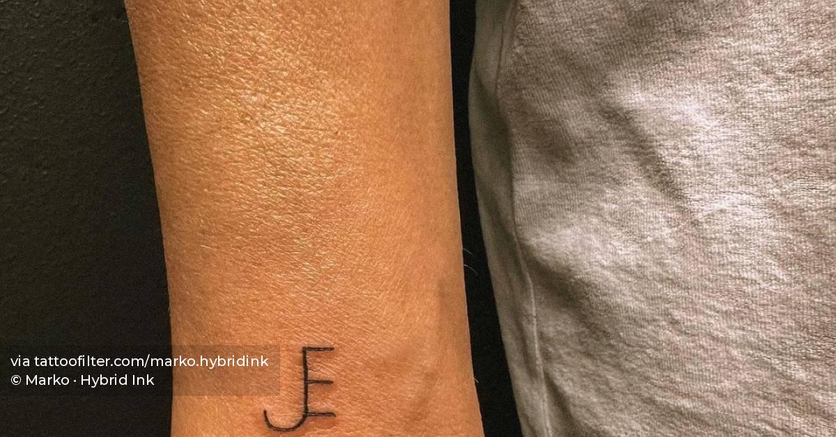 Minimalistic style initials tattoo located on the