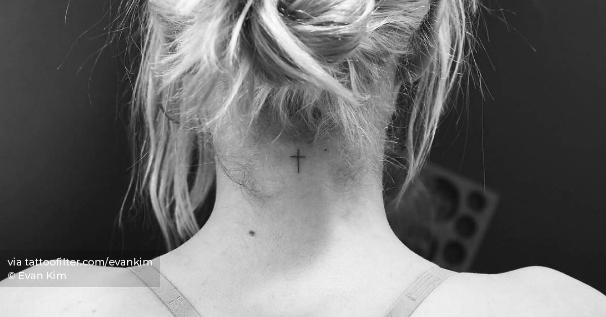 Little minimalistic cross tattooed on the back of the