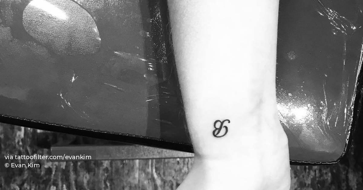 Minimalistic tattoo of the letter "B" located on the