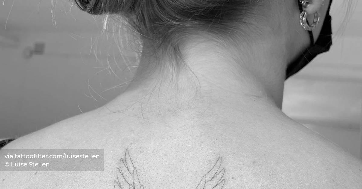 Fine line wings tattoo on the upper back.