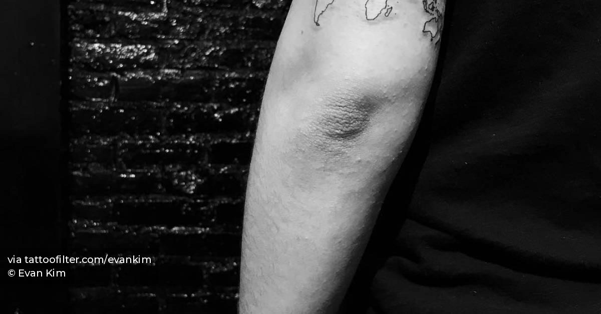 World map tattoo located on the tricep, fine line