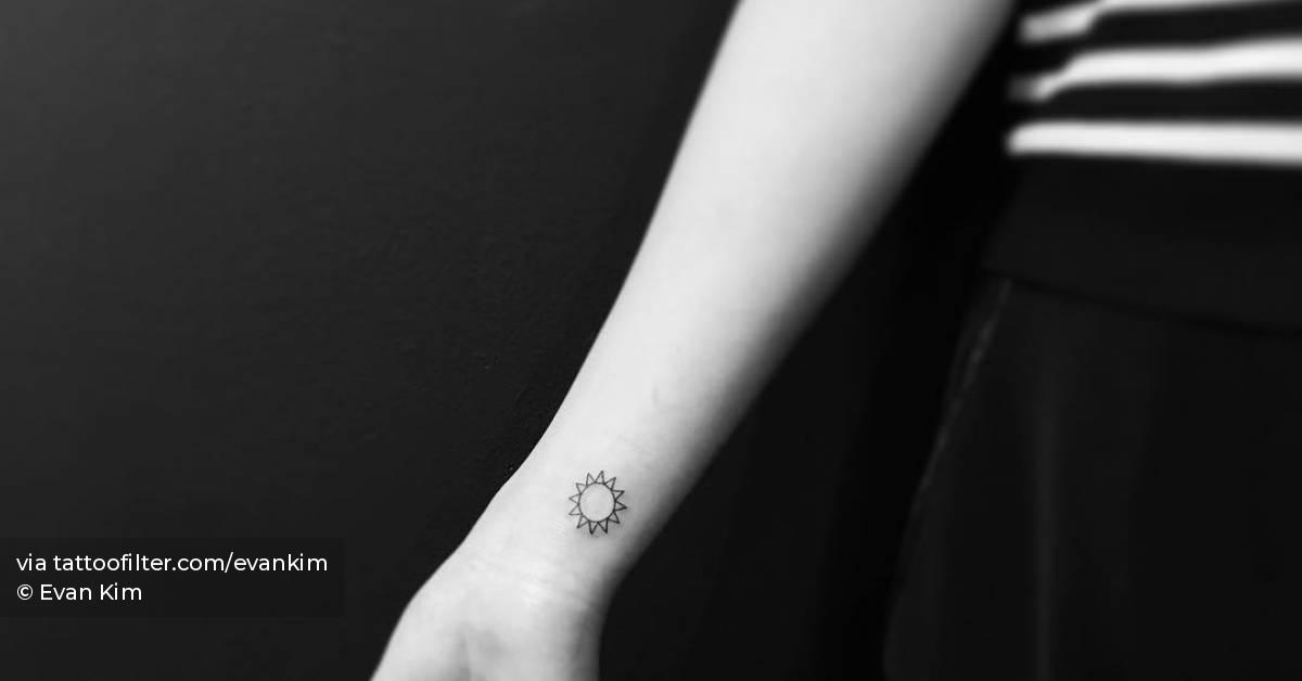 Minimalistic style sun tattoo done on the wrist.