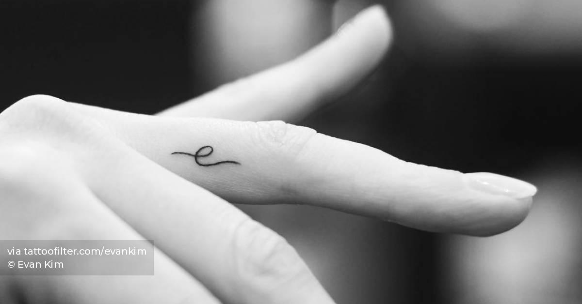 Minimalistic style letter "E" tattoo located on the