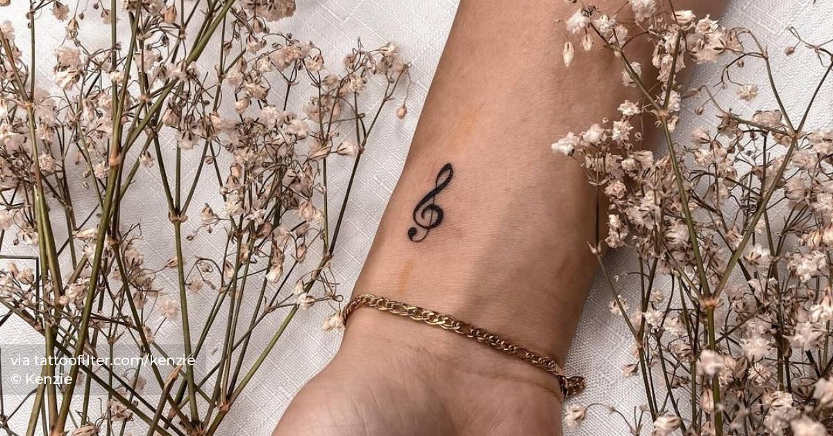 Minimalistic style treble clef tattoo placed on the