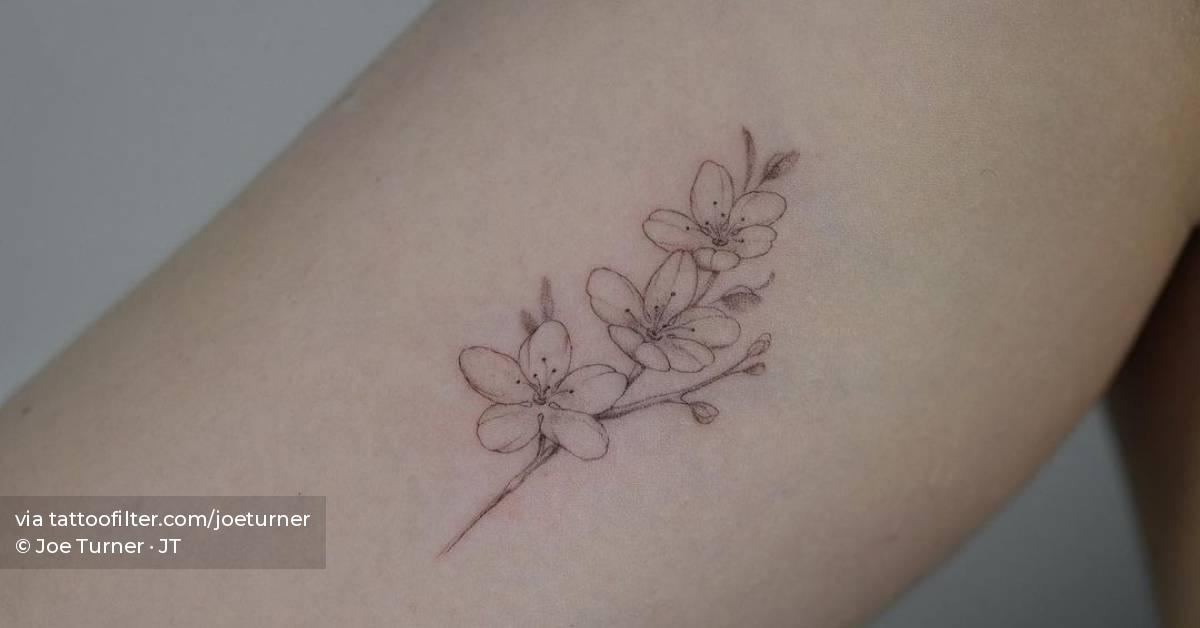 Fine line style cherry blossom ttatoo located on the