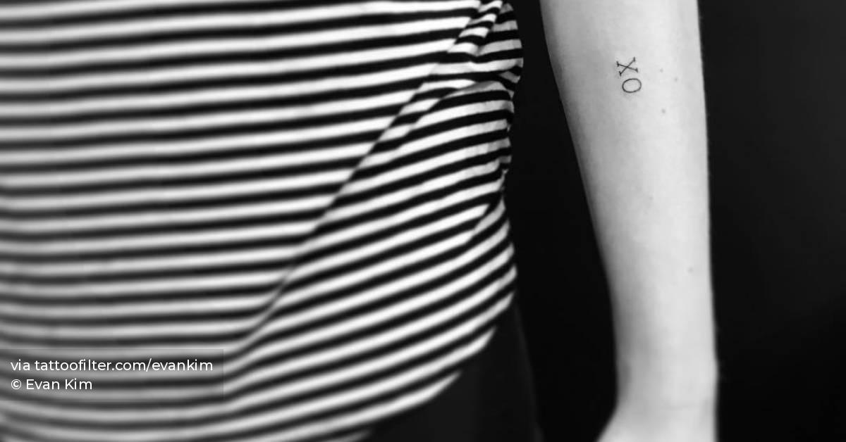 "XO" lettering tattoo located on the forearm.