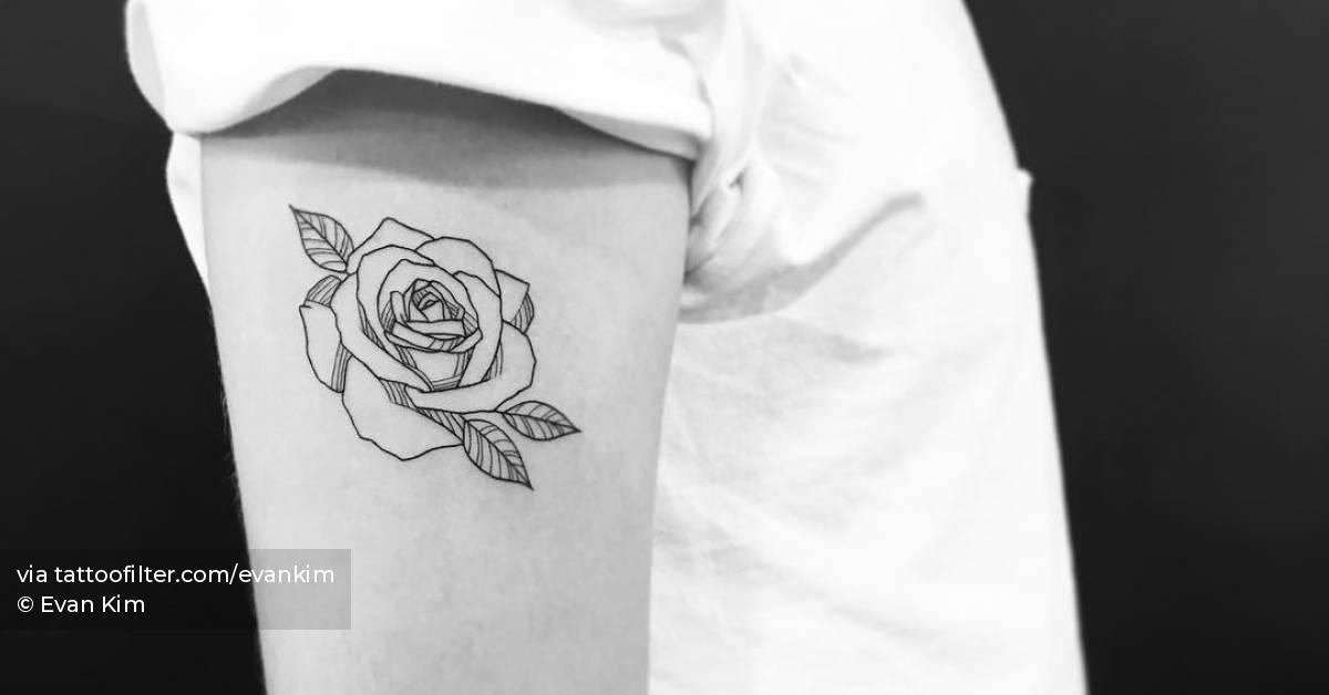 Fine line rose head tattoo located on the upper arm.