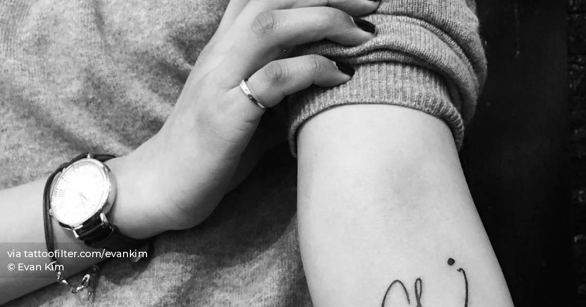 Initials "AJ" tattooed on the inner forearm.